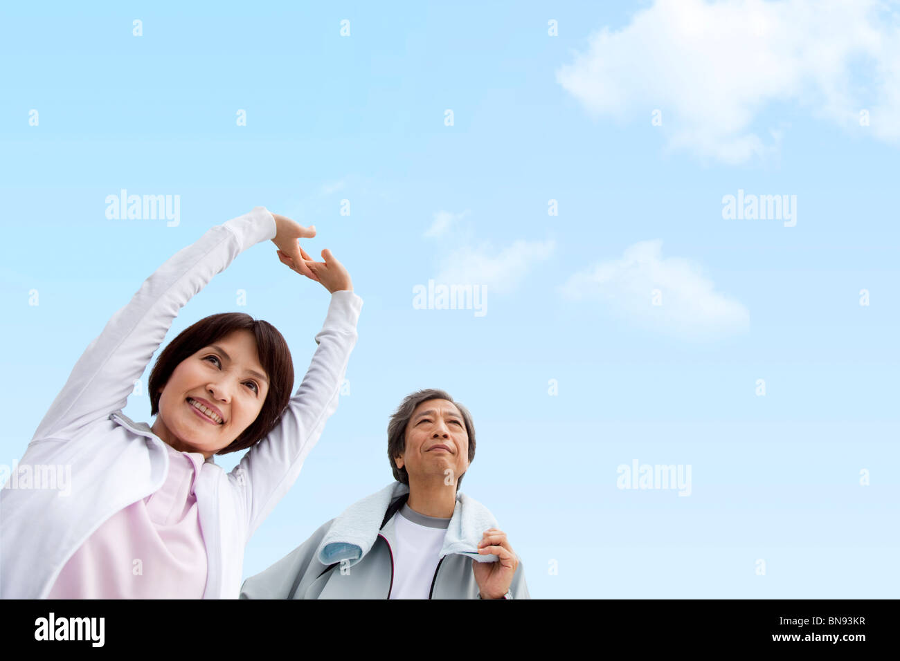 Mature couple in sports clothing stretching Stock Photo - Alamy