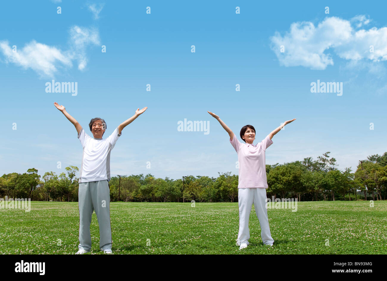 Mature couple in sports clothing stretching Stock Photo - Alamy