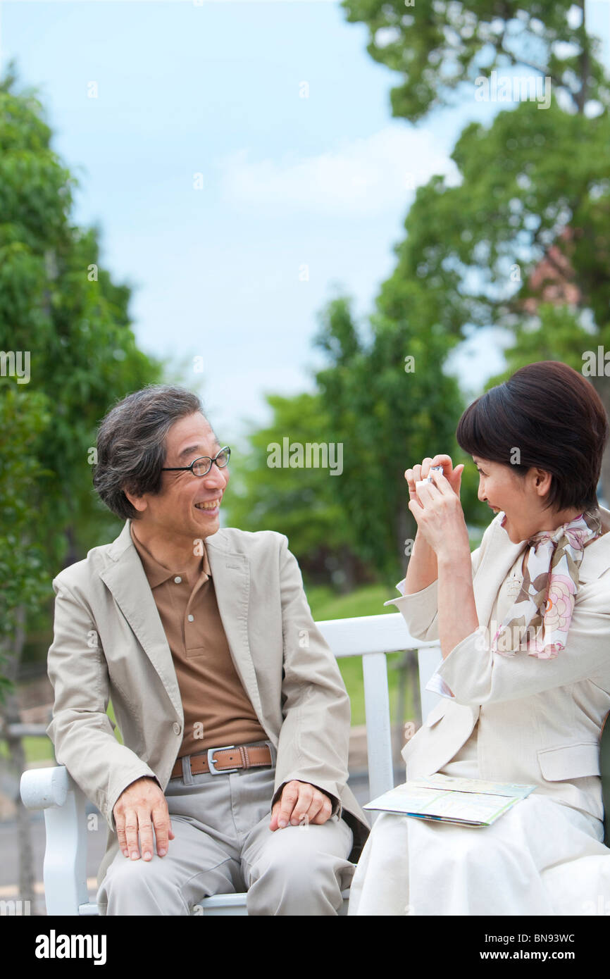 Mature woman taking picture of mature man Stock Photo - Alamy