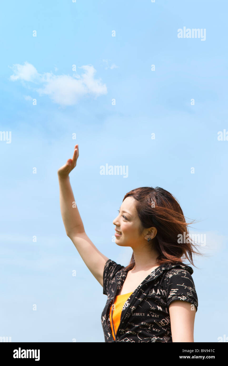Woman standing and hand raised Stock Photo - Alamy