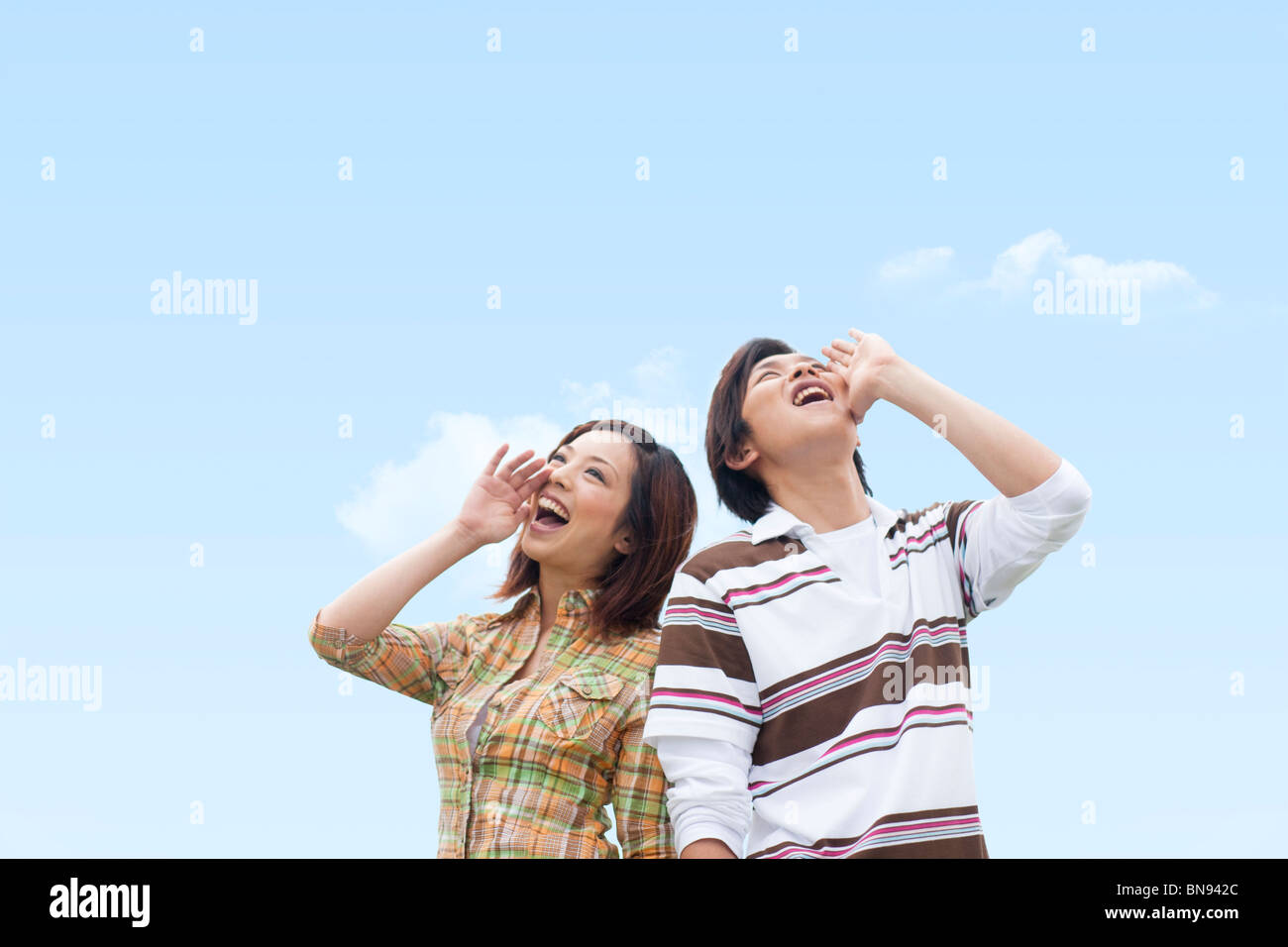 Young Man and Woman Shouting Under Blue Sky Stock Photo - Alamy