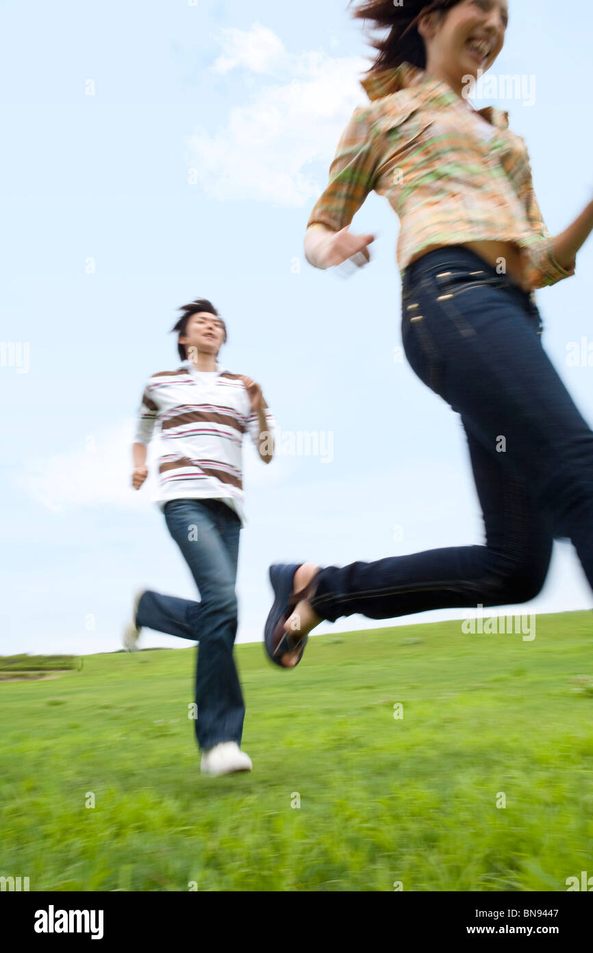 Young Man and Woman Running in Green Field Stock Photo - Alamy
