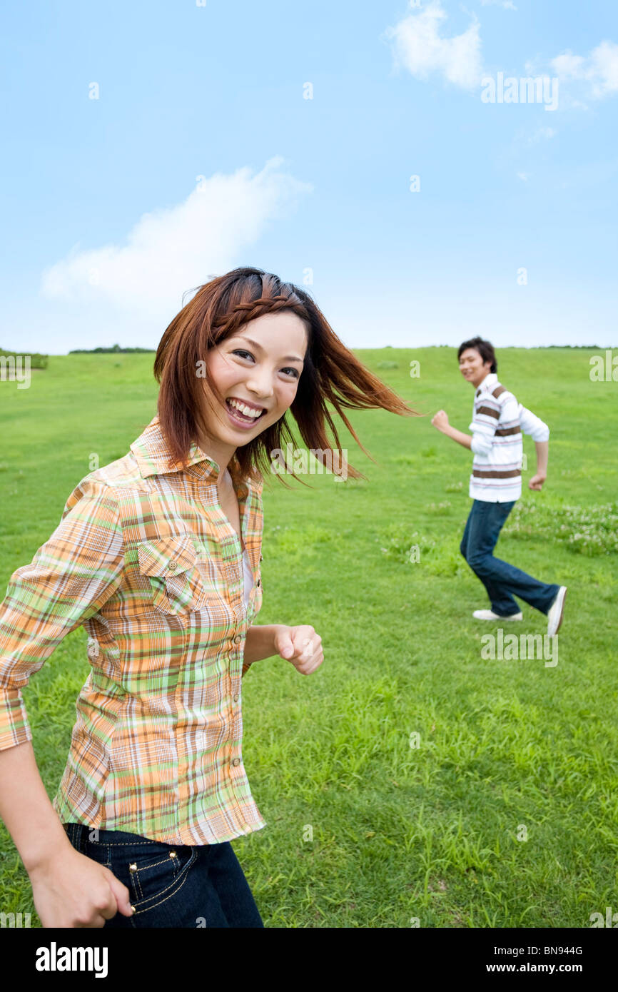 Young Man and Woman Running in Green Field Stock Photo - Alamy