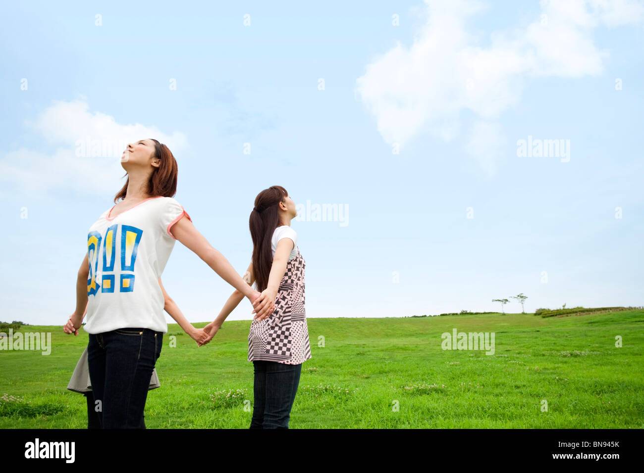 Three Women Holding Hands Standing Back to Back Stock Photo - Alamy