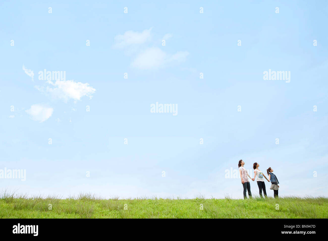 Three Young Women Holding Hands Looking Up Sky Stock Photo - Alamy
