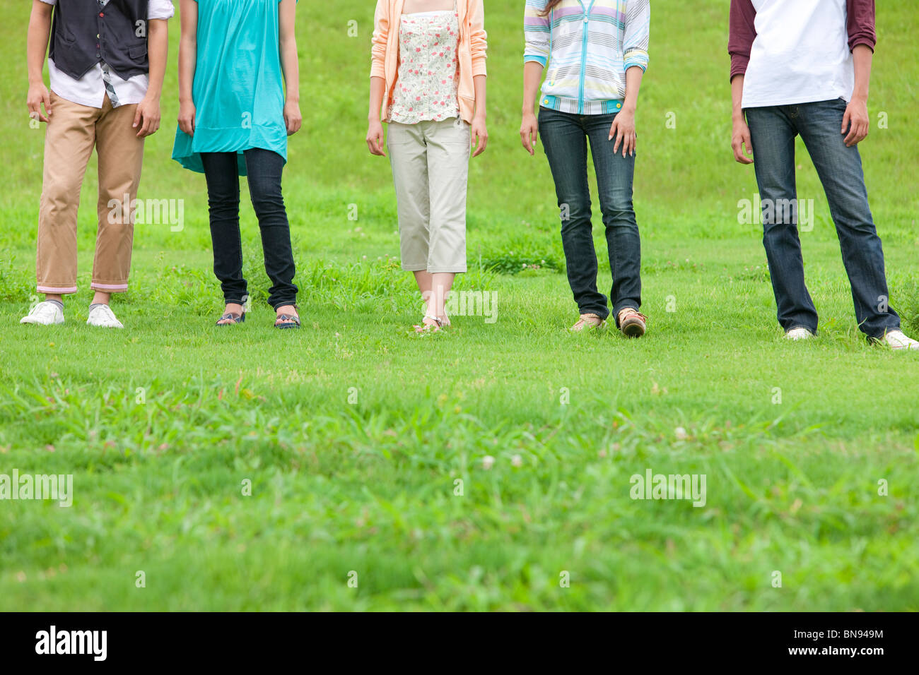 Five young people standing side by side in field Stock Photo - Alamy
