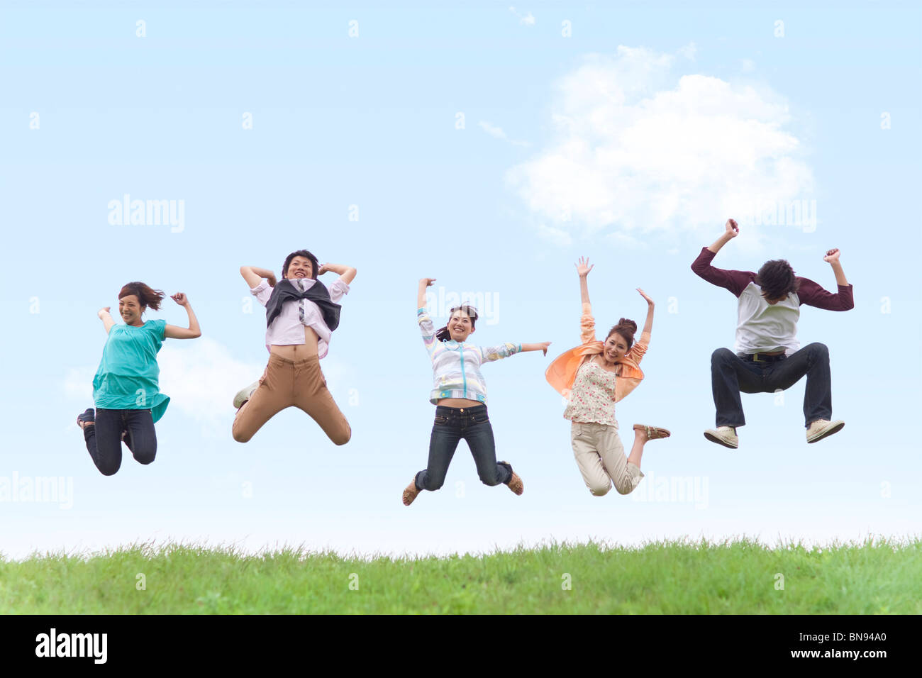 Five young people jumping in field Stock Photo - Alamy