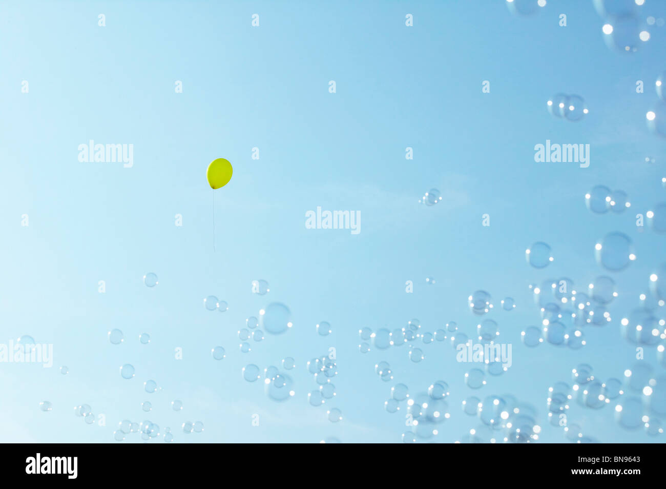 A yellow balloon and bubbles floating in the sky Stock Photo - Alamy