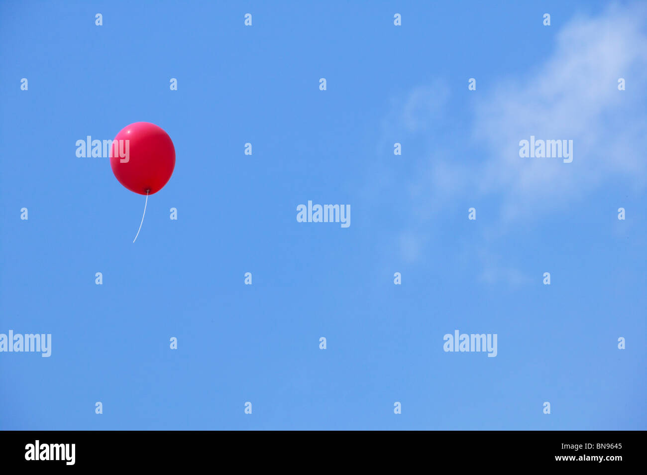 A single red balloon floating in the sky Stock Photo - Alamy