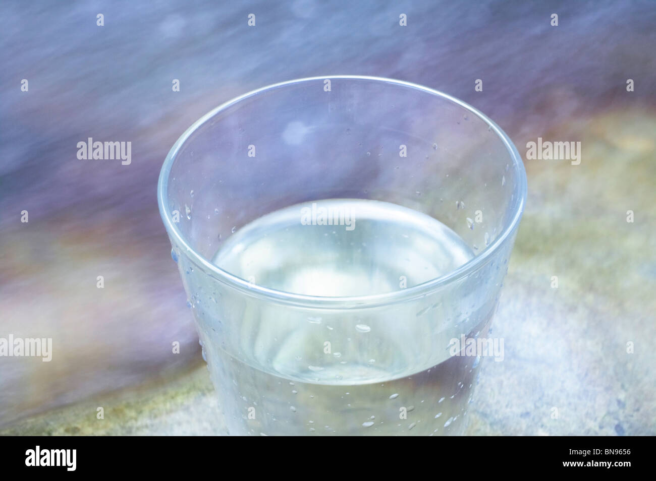 Glass of water next to a flowing stream Stock Photo - Alamy