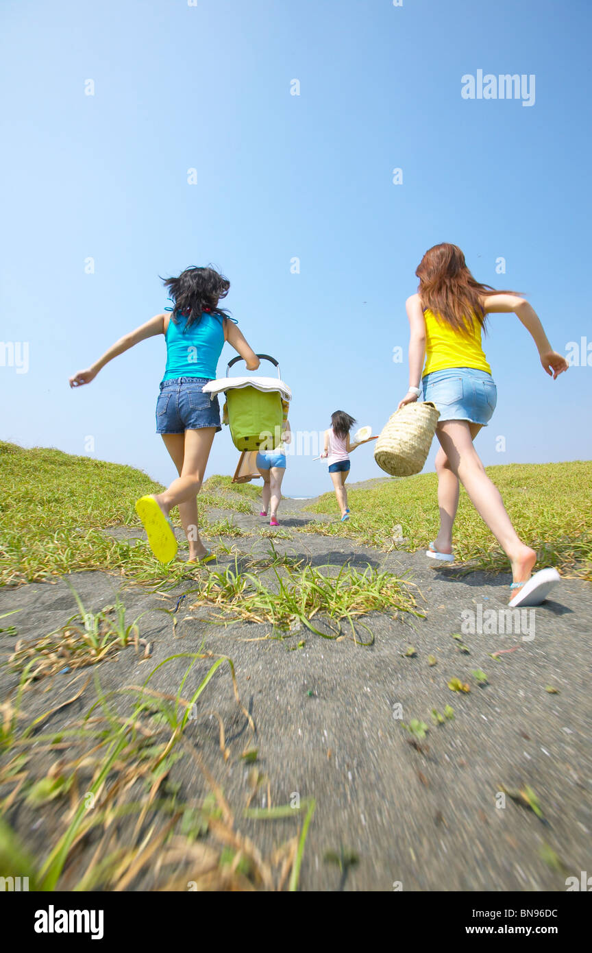 Four friends running to the beach Stock Photo - Alamy