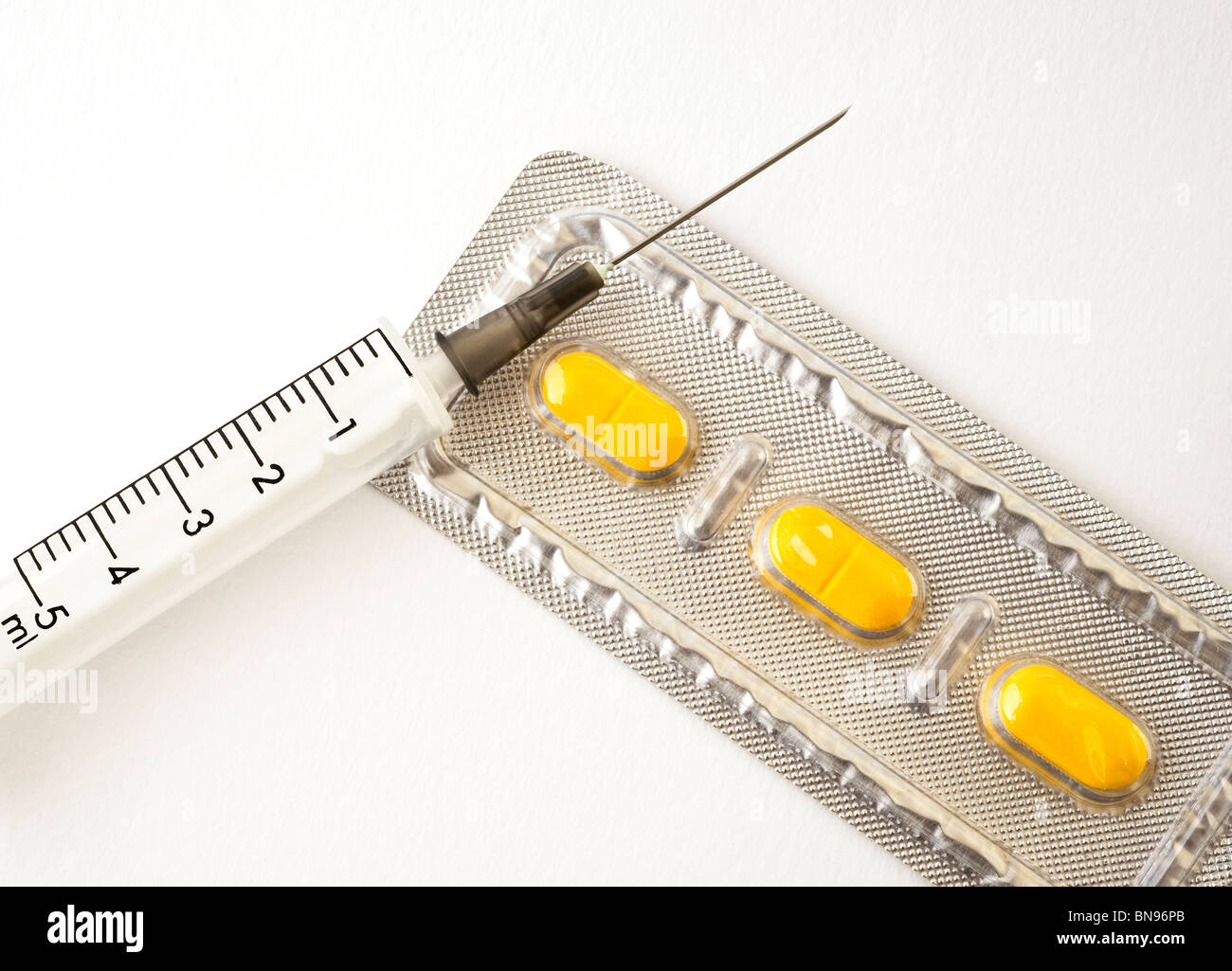 Medical syringe and a strip of pills isolated on a white background ...