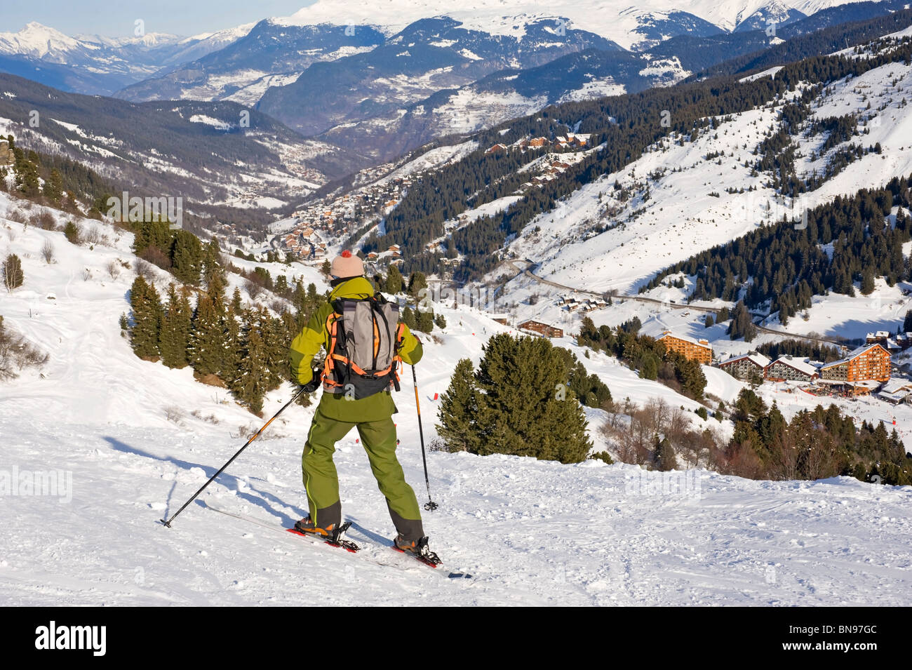 Skier looking down a snowy mountain valley scene Stock Photo - Alamy