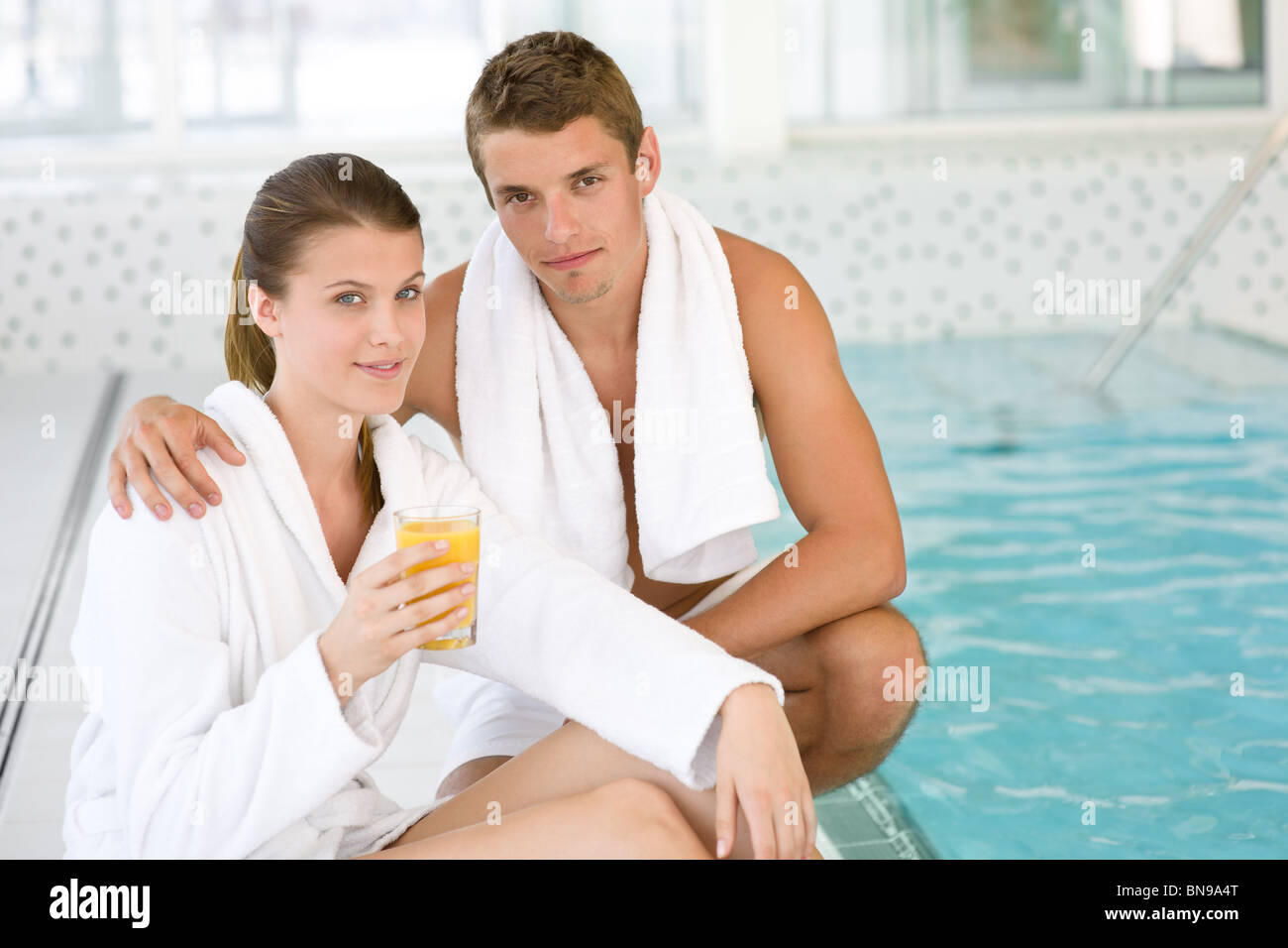 Luxury spa - young sportive couple relax at swimming pool in hotel ...