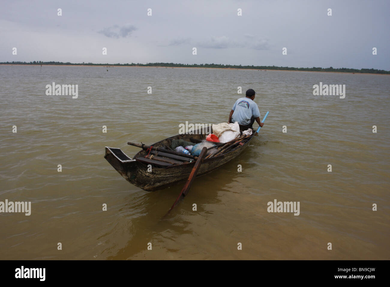 A fisherman punts his boat across the Western Baray, Angkor ...