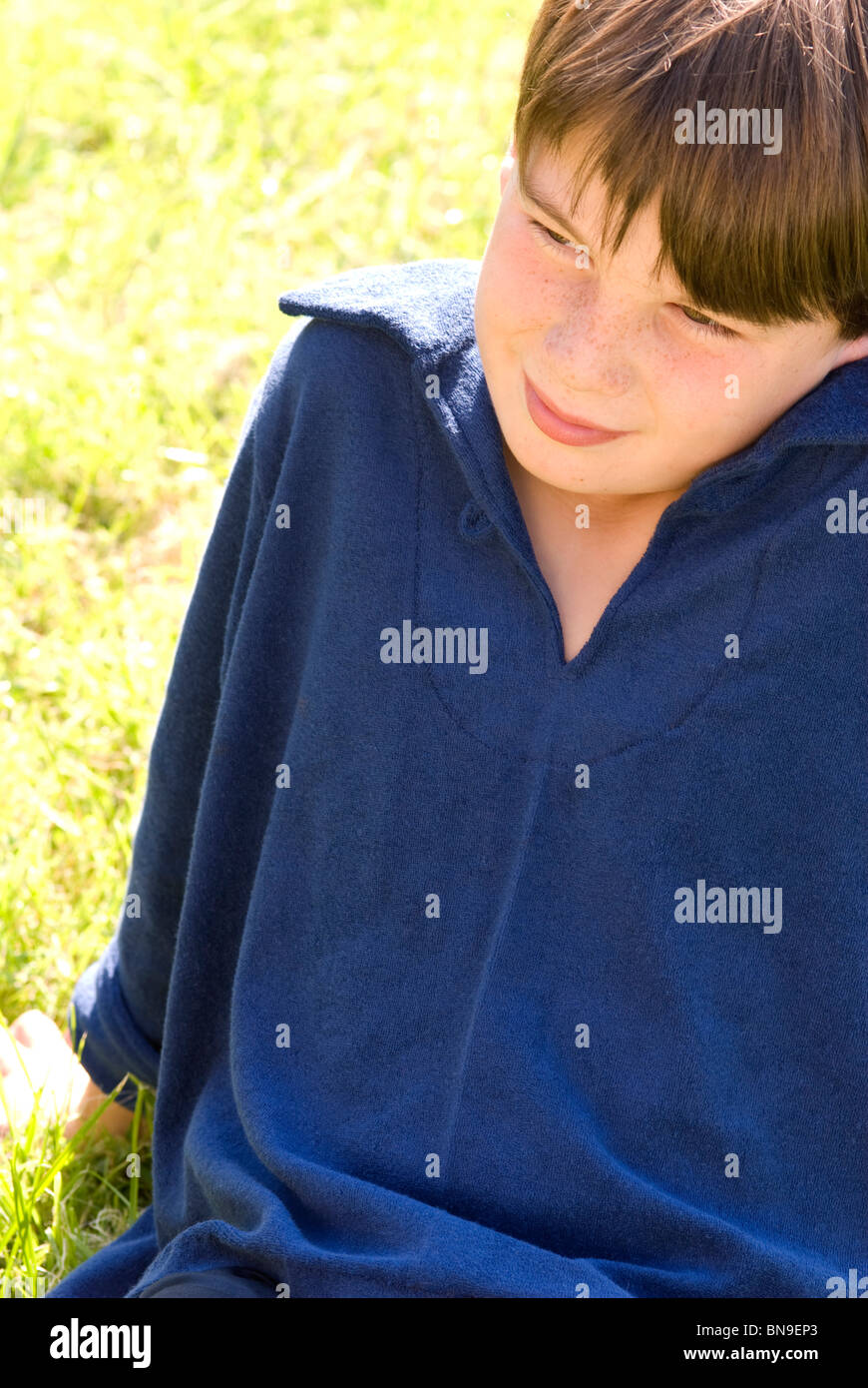 Boy sitting and leaning back on the grass Stock Photo - Alamy