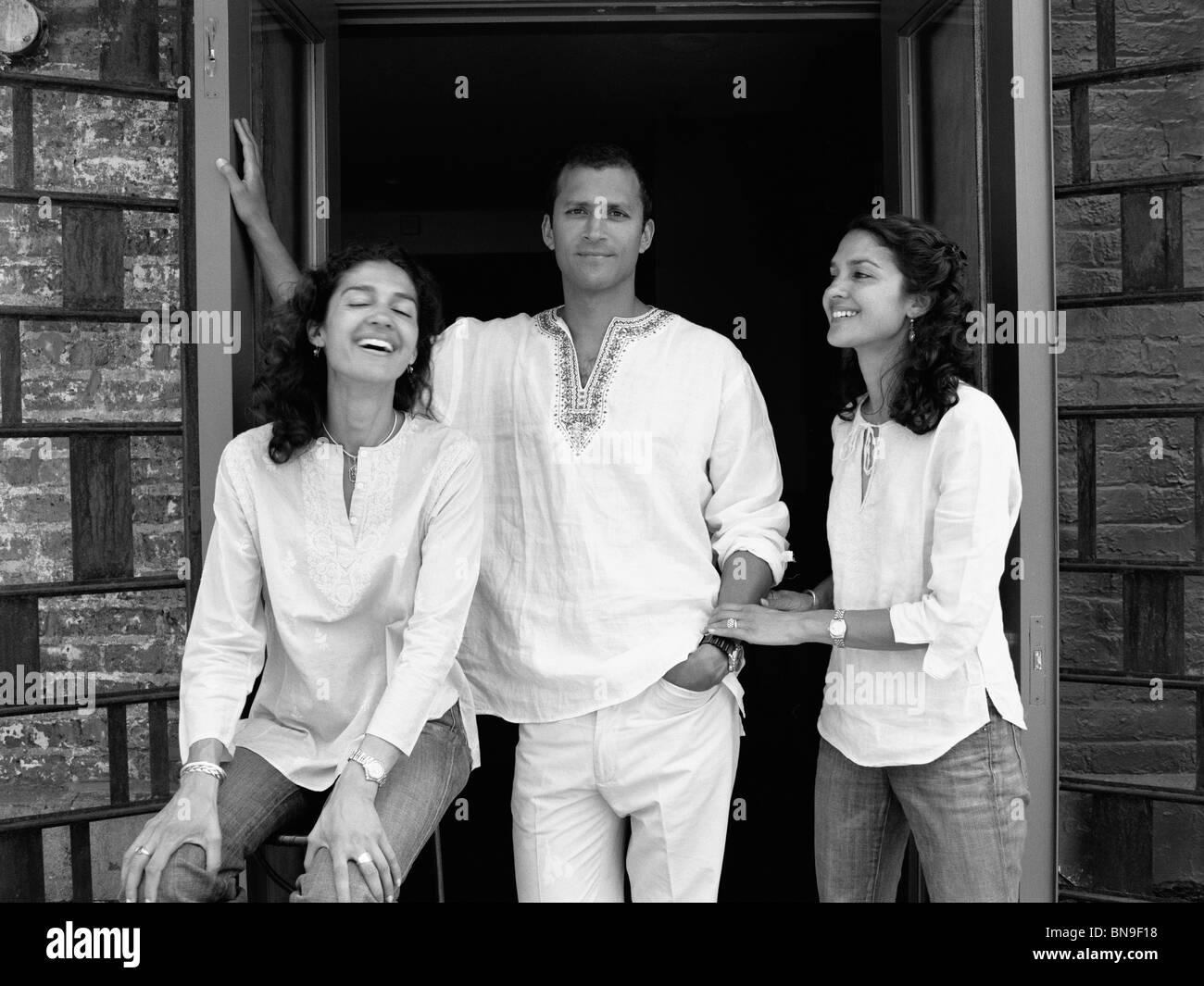 Friends standing in doorway Stock Photo - Alamy