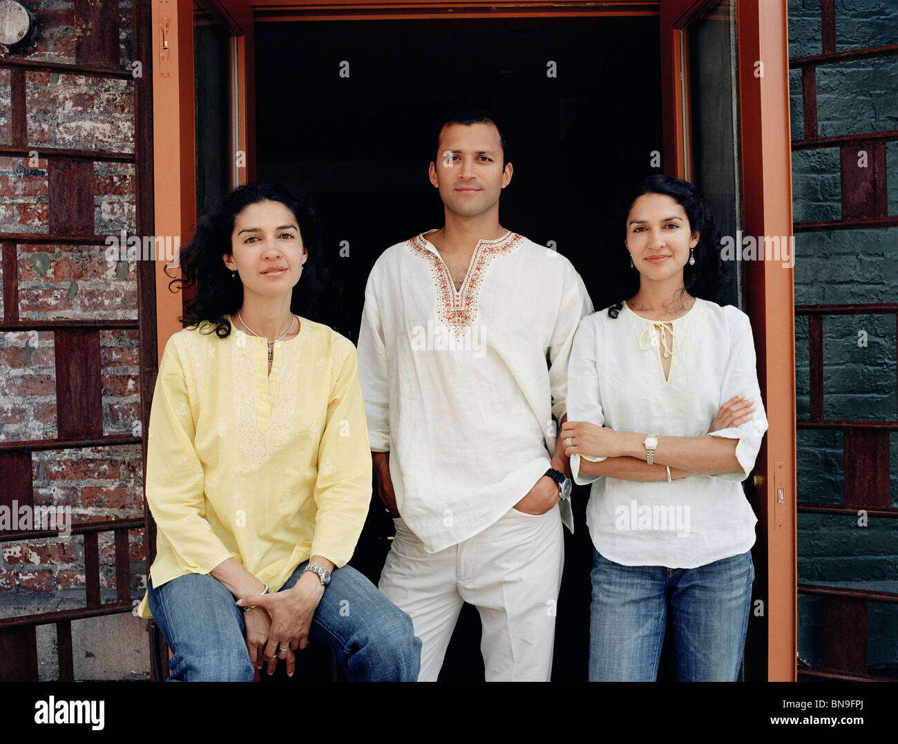 Friends standing in doorway Stock Photo - Alamy