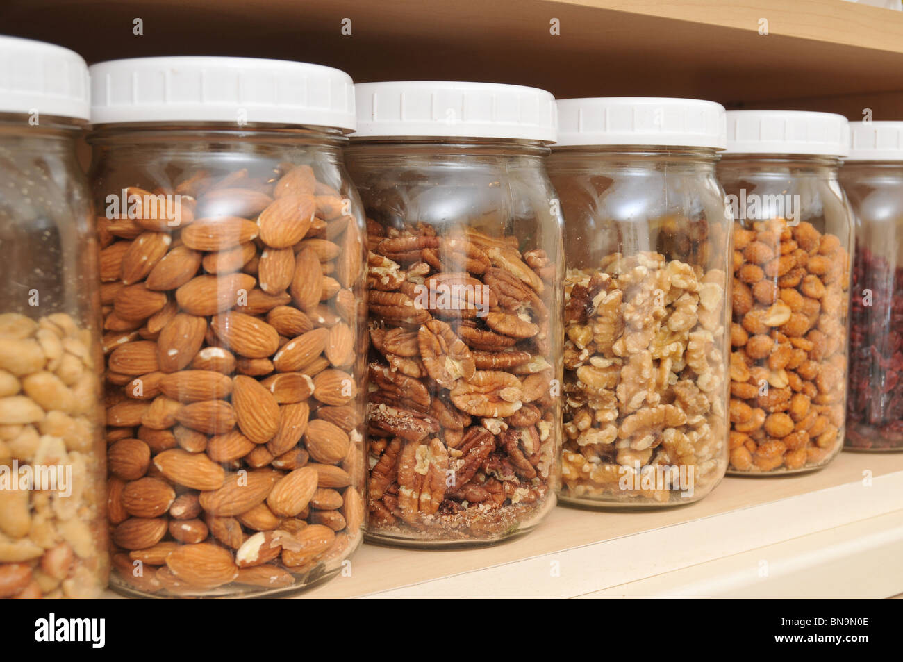 Healthy Nuts in Glass Jars sitting on a shelf Stock Photo - Alamy