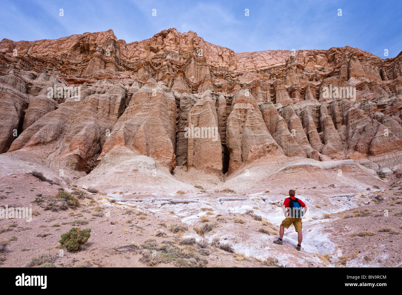 A hiker approaching the surreal red cliffs of Red Rocks Canyon State ...