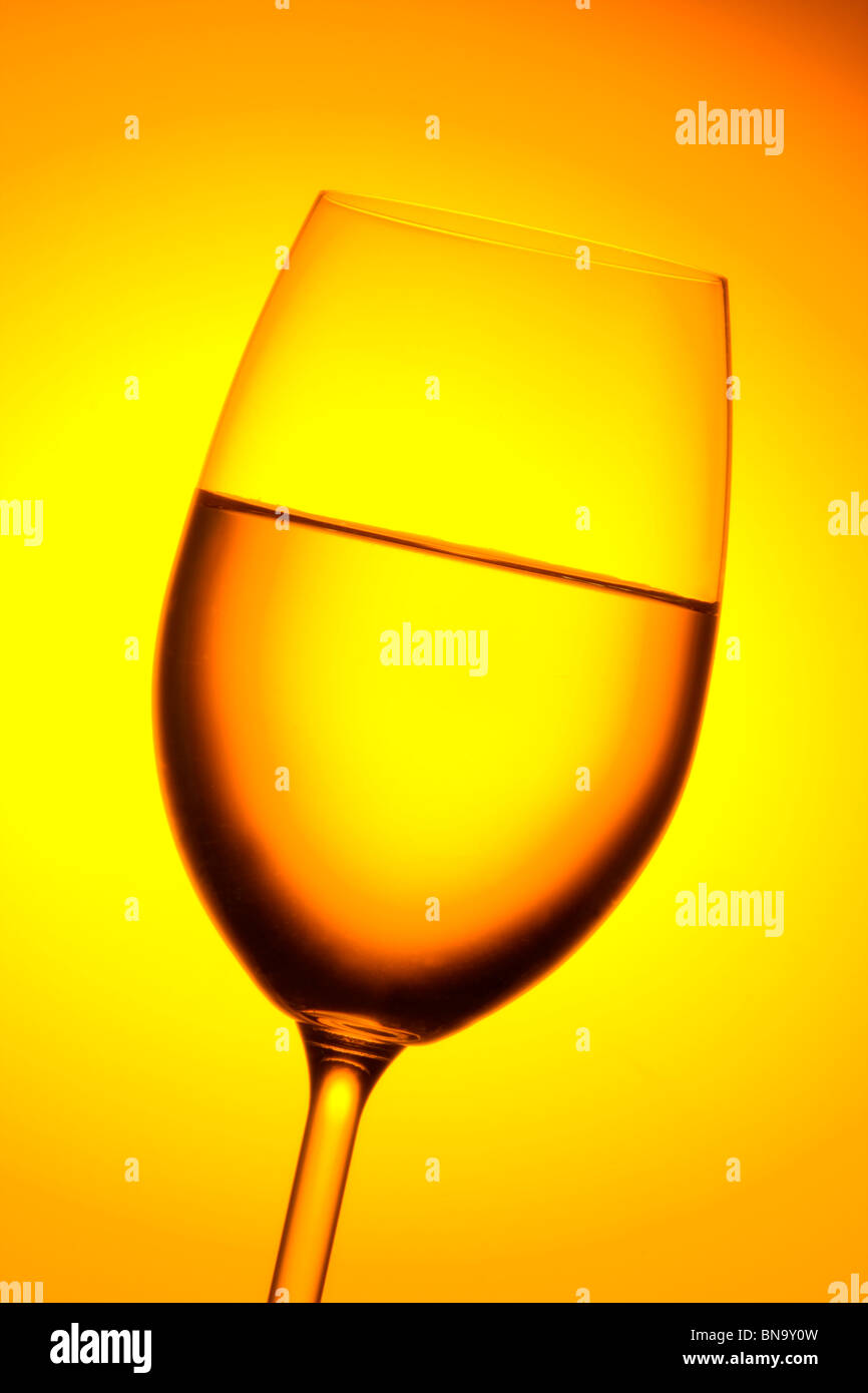 White wine in a wineglass on yellow atmospheric background Stock Photo ...