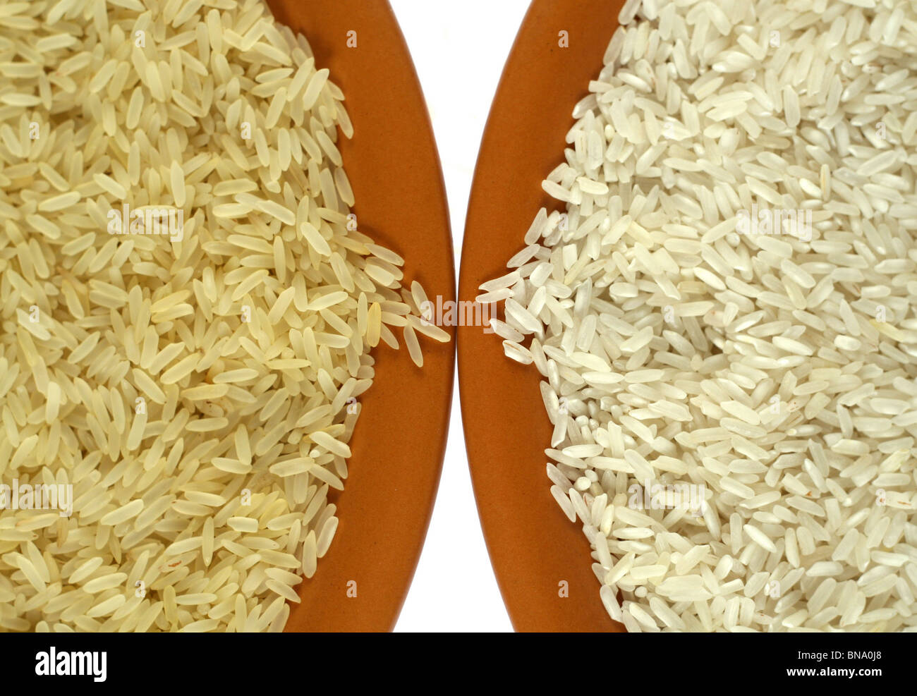White and yellow (parboiled) rice in two ceramic plates isolated on ...