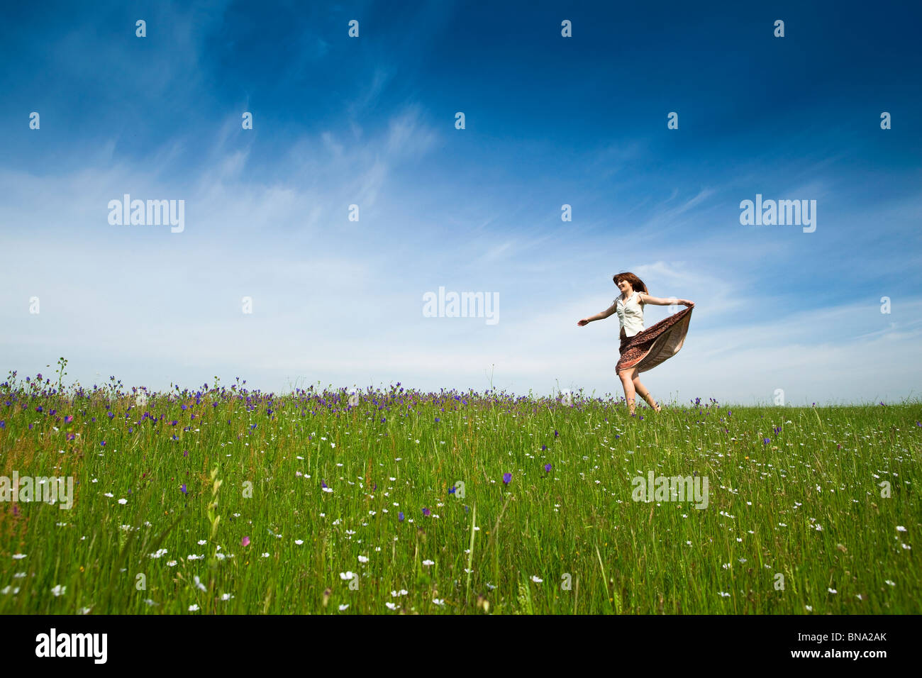 Young woman dancing on a beautiful green meadow Stock Photo - Alamy