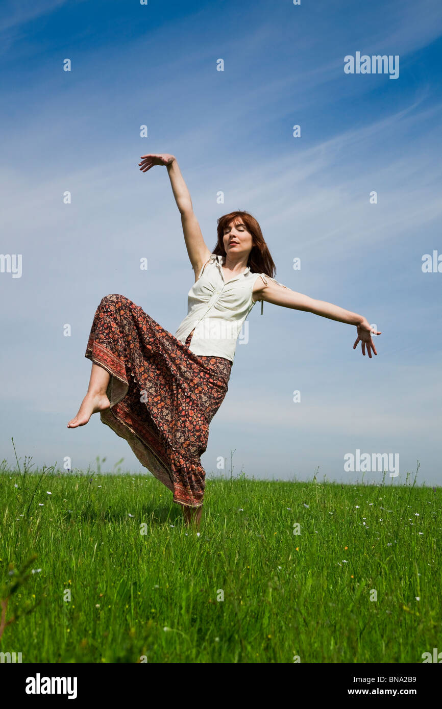Young woman making dancing poses on a beautiful green meadow Stock ...