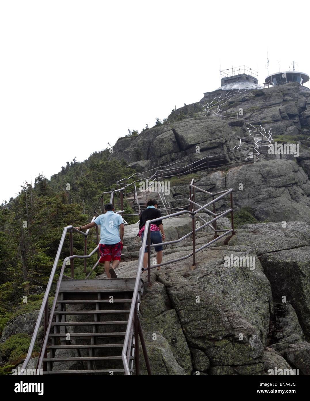Tourists in various stages of climbing the rock stairs along the ridge ...