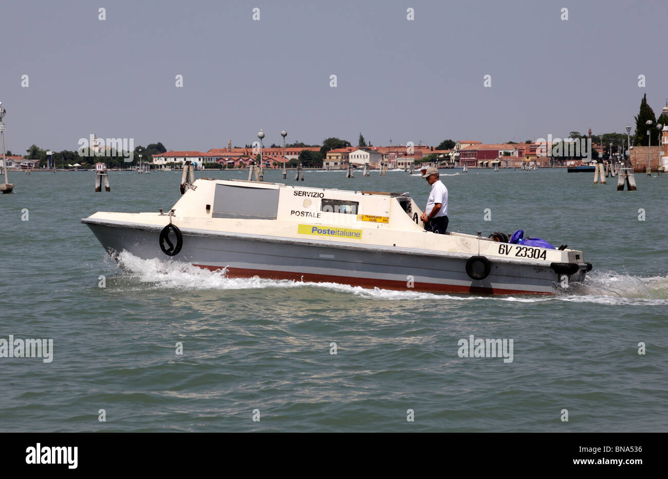 A postal or mail service delivery boat on the canal Venice Italy Stock ...