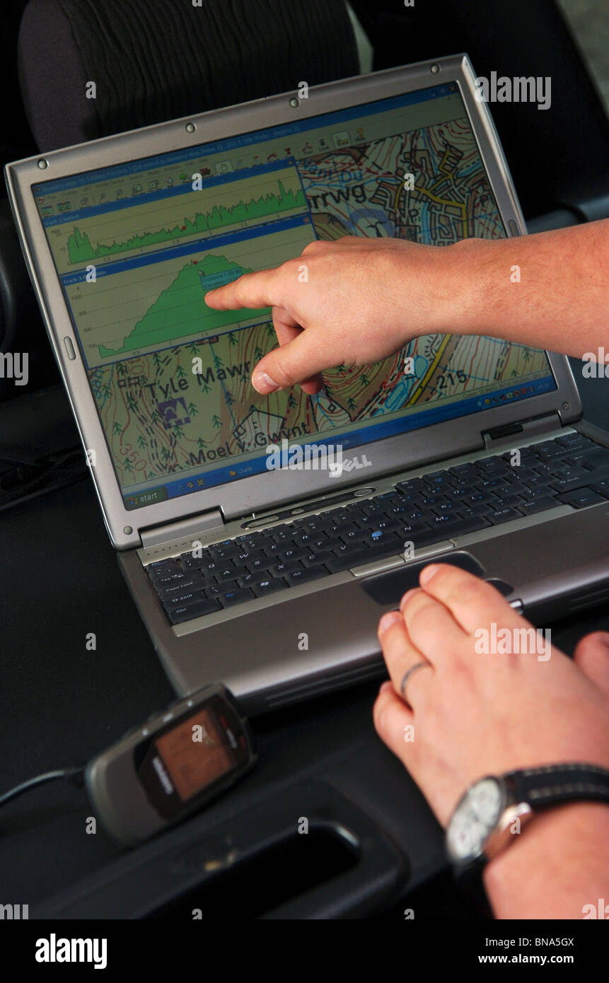 A man plots a route on a laptop from a global positioning system Stock ...