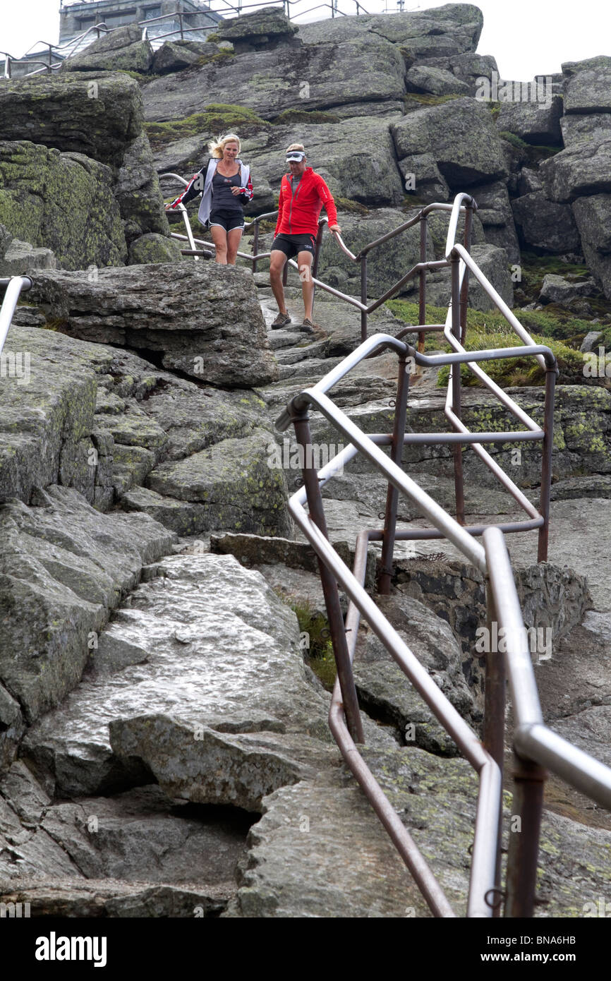 Tourists in various stages of climbing the rock stairs along the ridge ...