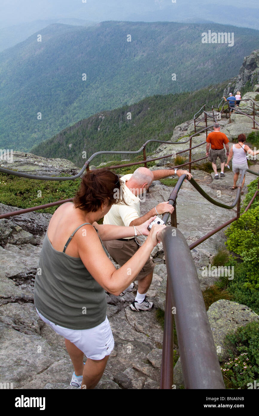 Tourists in various stages of climbing the rock stairs along the ridge ...