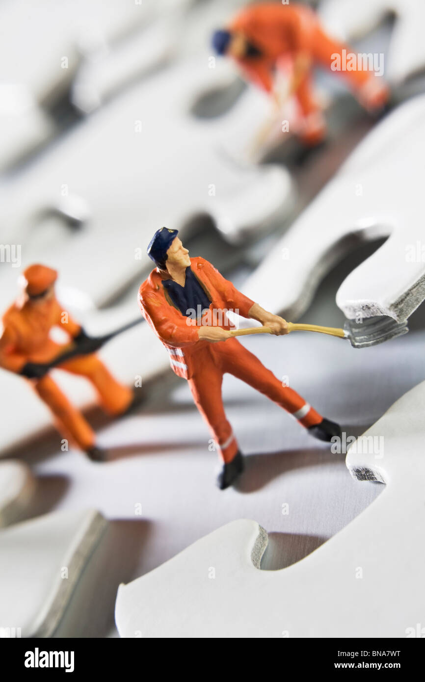 Worker figurines placed with puzzle pieces Stock Photo - Alamy