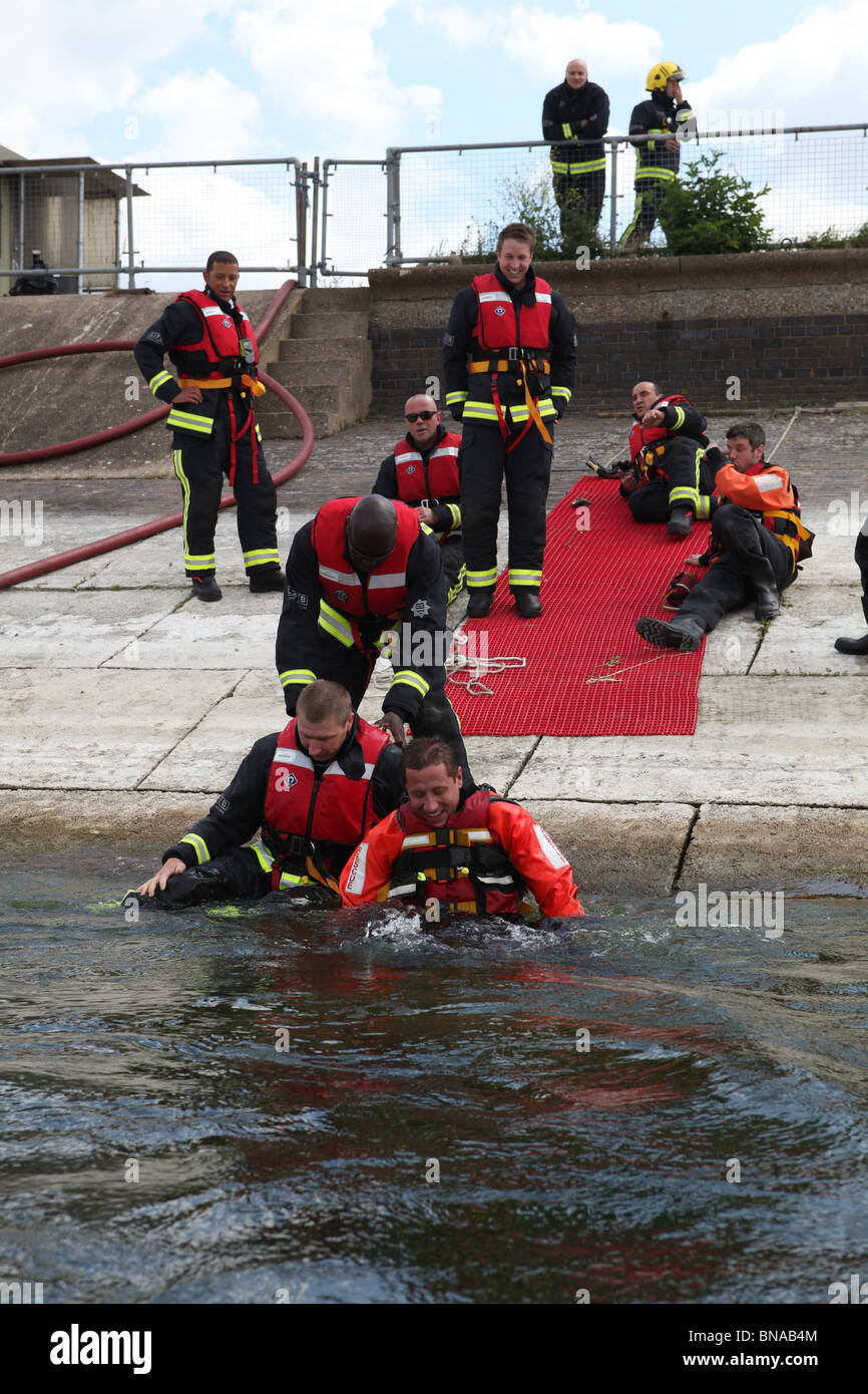 fireman training to save a person who is drowning in open water. they ...