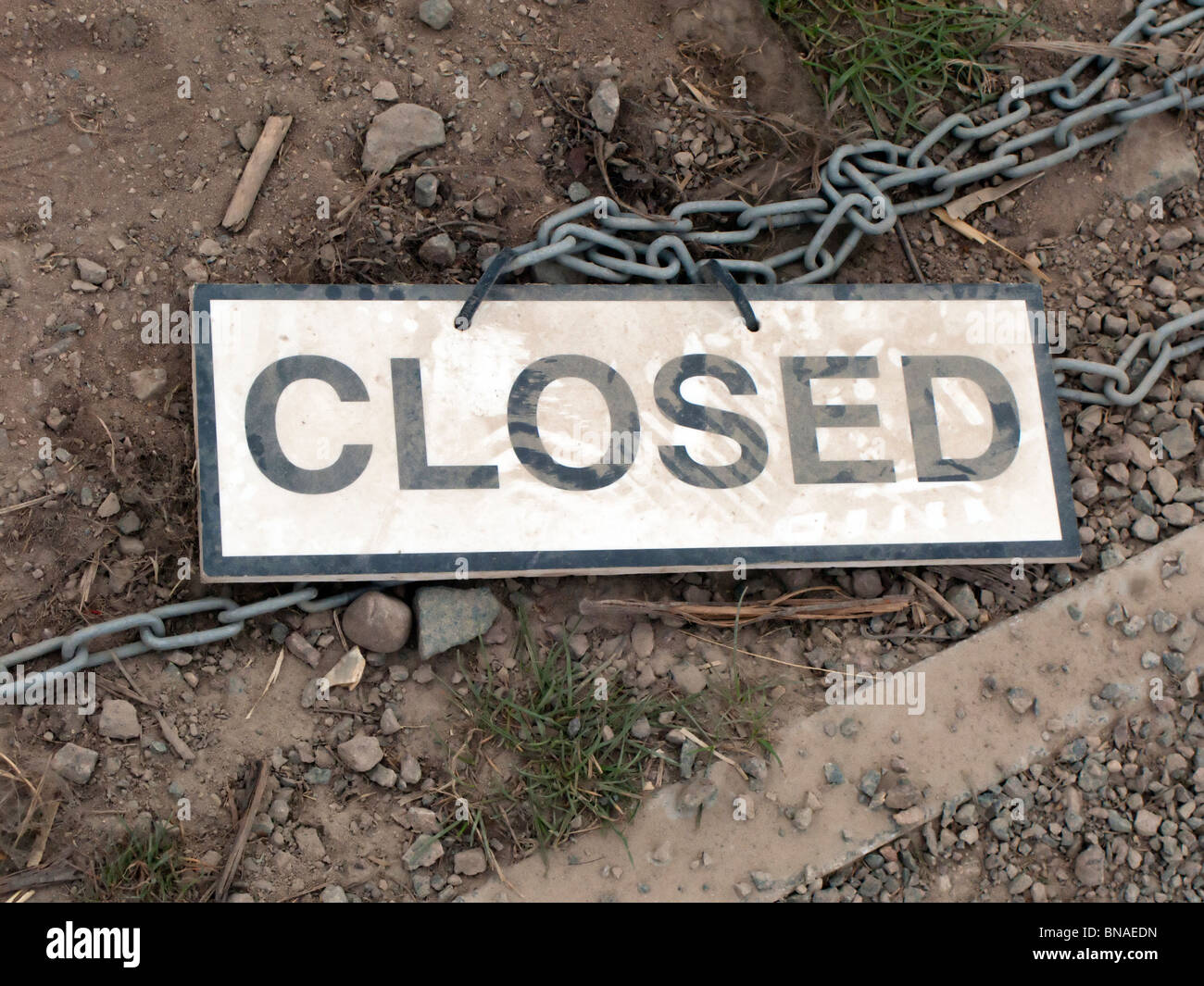Closed sign and chain lying on ground Stock Photo - Alamy