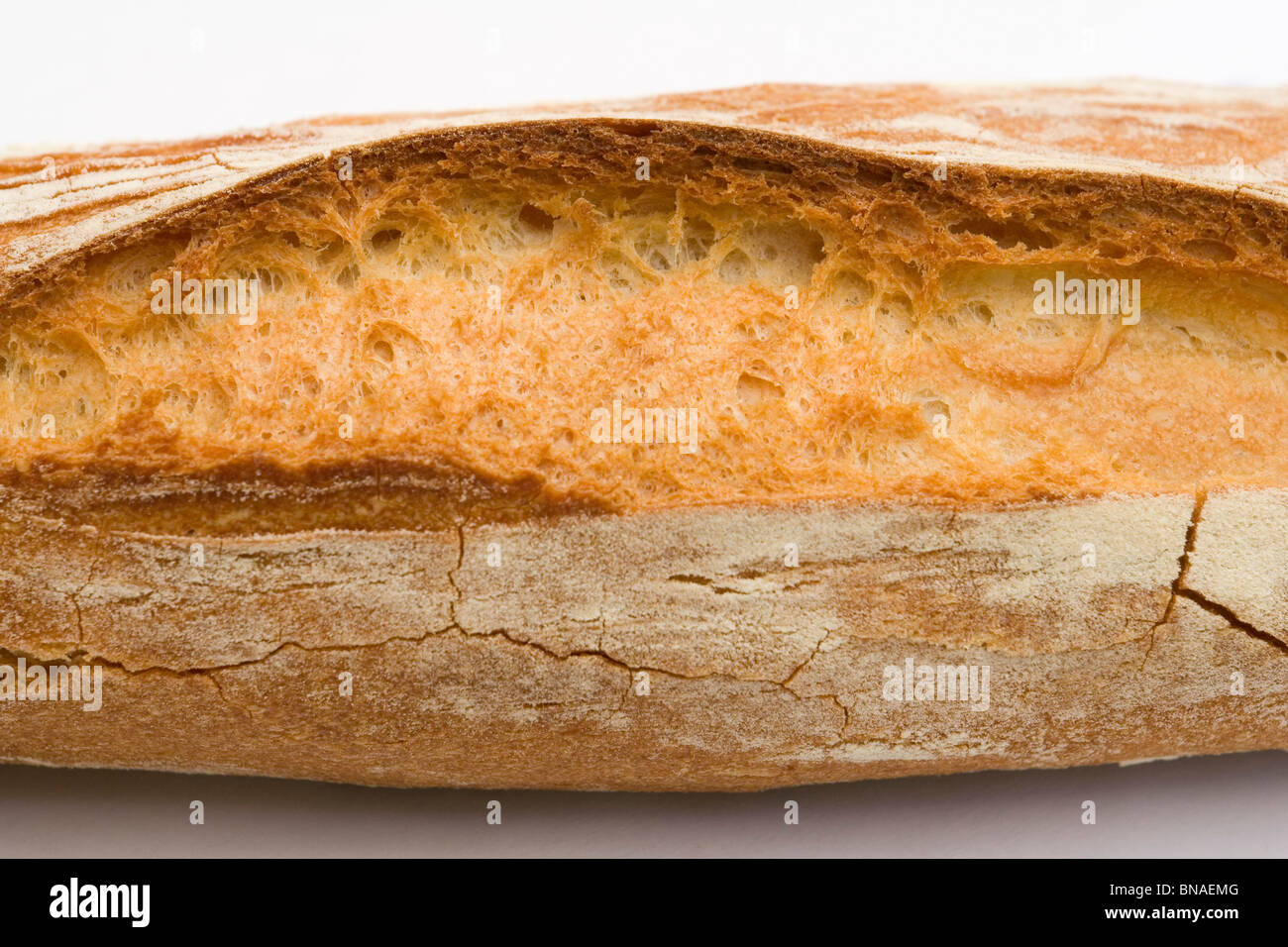 A part of a traditional French stick of bread on a white background ...
