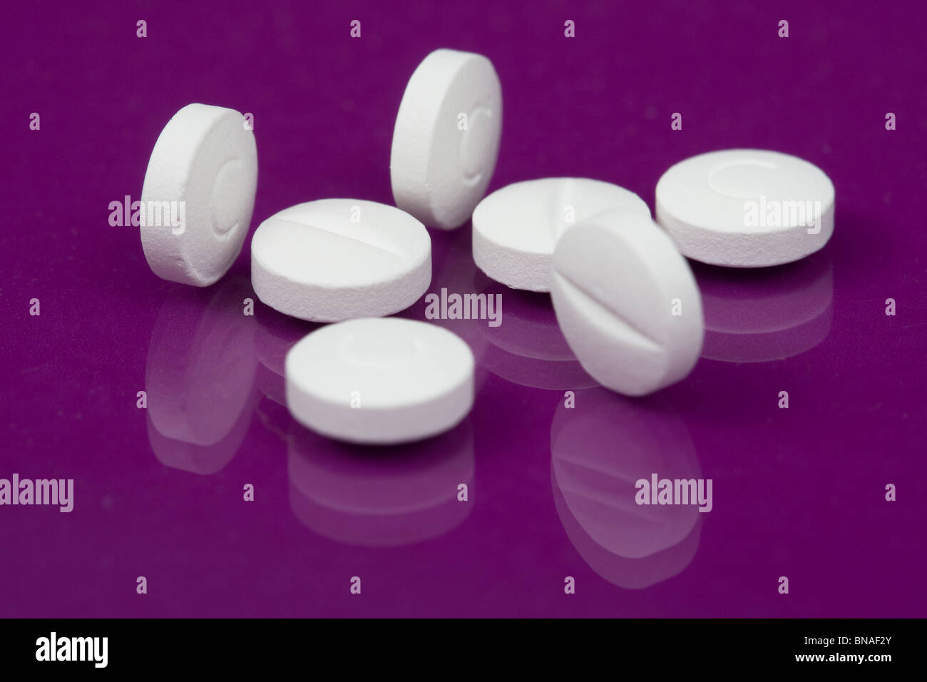 Tablets on purple background Stock Photo - Alamy