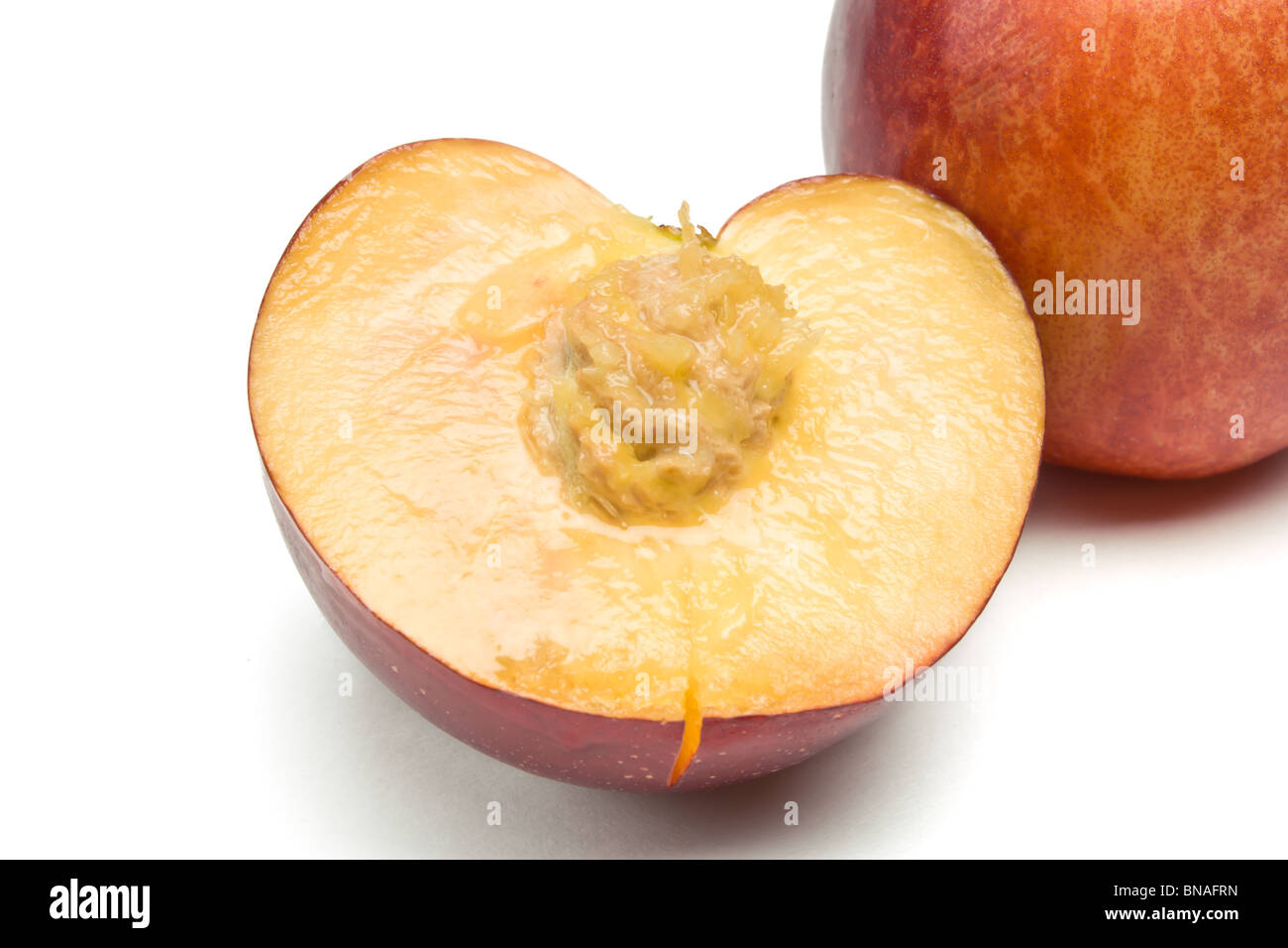 fresh vibrant Nectarine half with stone from low perspective isolated ...
