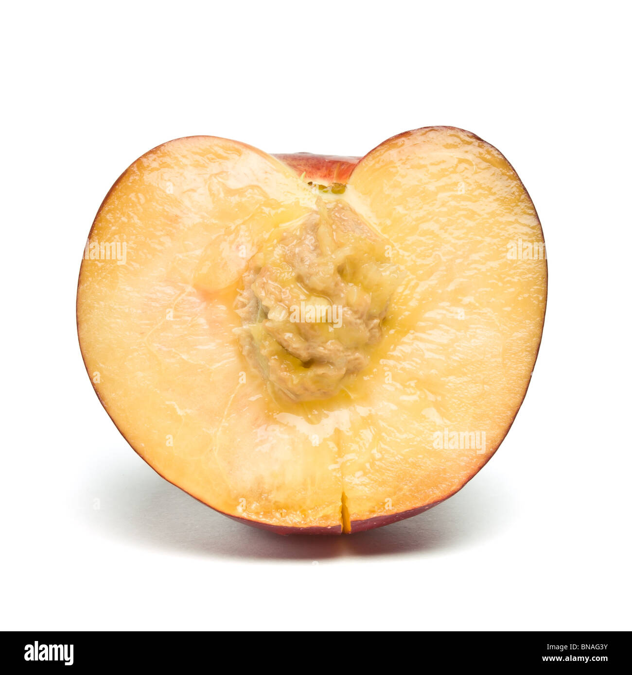 fresh vibrant Nectarine half with stone from low perspective isolated ...