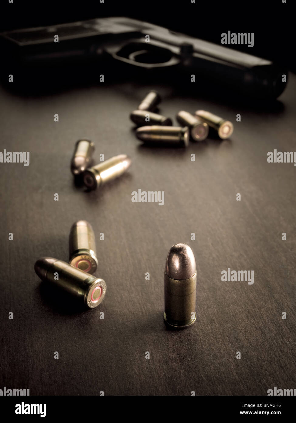 bullets with handgun in the back of the scene with focus on the bullet ...