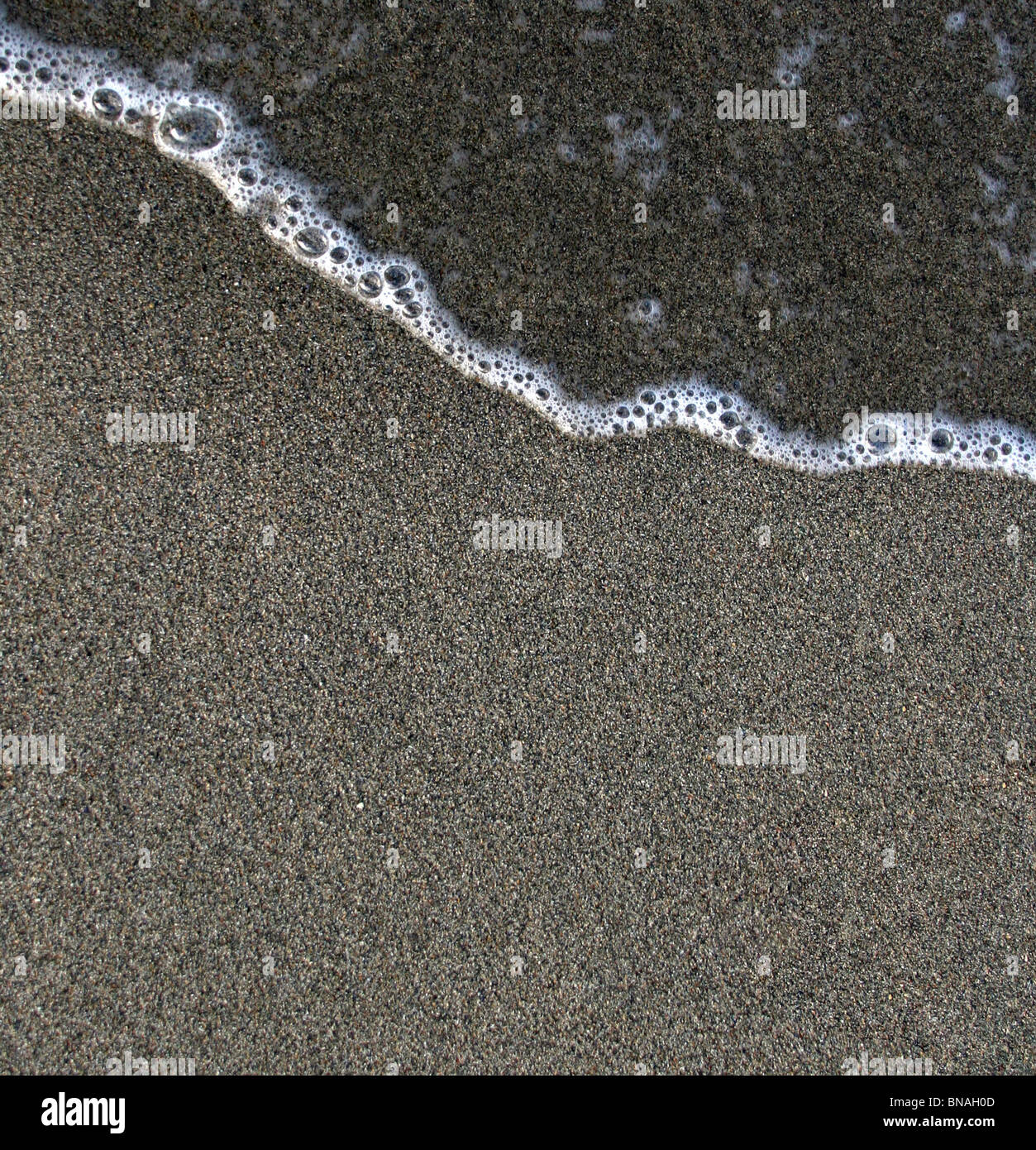 Wave on sand Stock Photo - Alamy