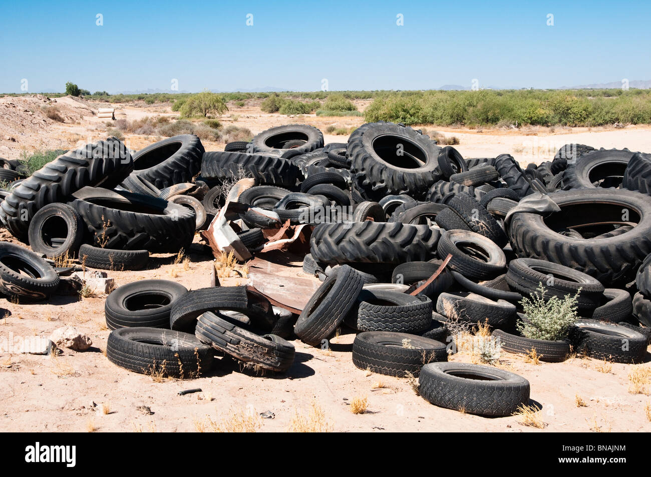 A pile of worn-out rubber tires have been dumped in the desert Stock ...