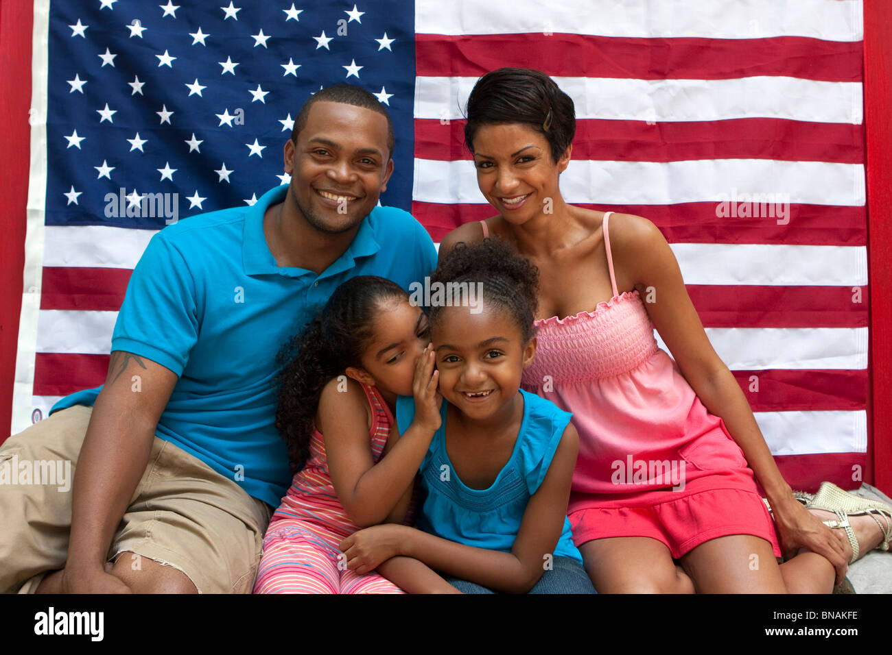 Family sitting in front American Flag Stock Photo - Alamy