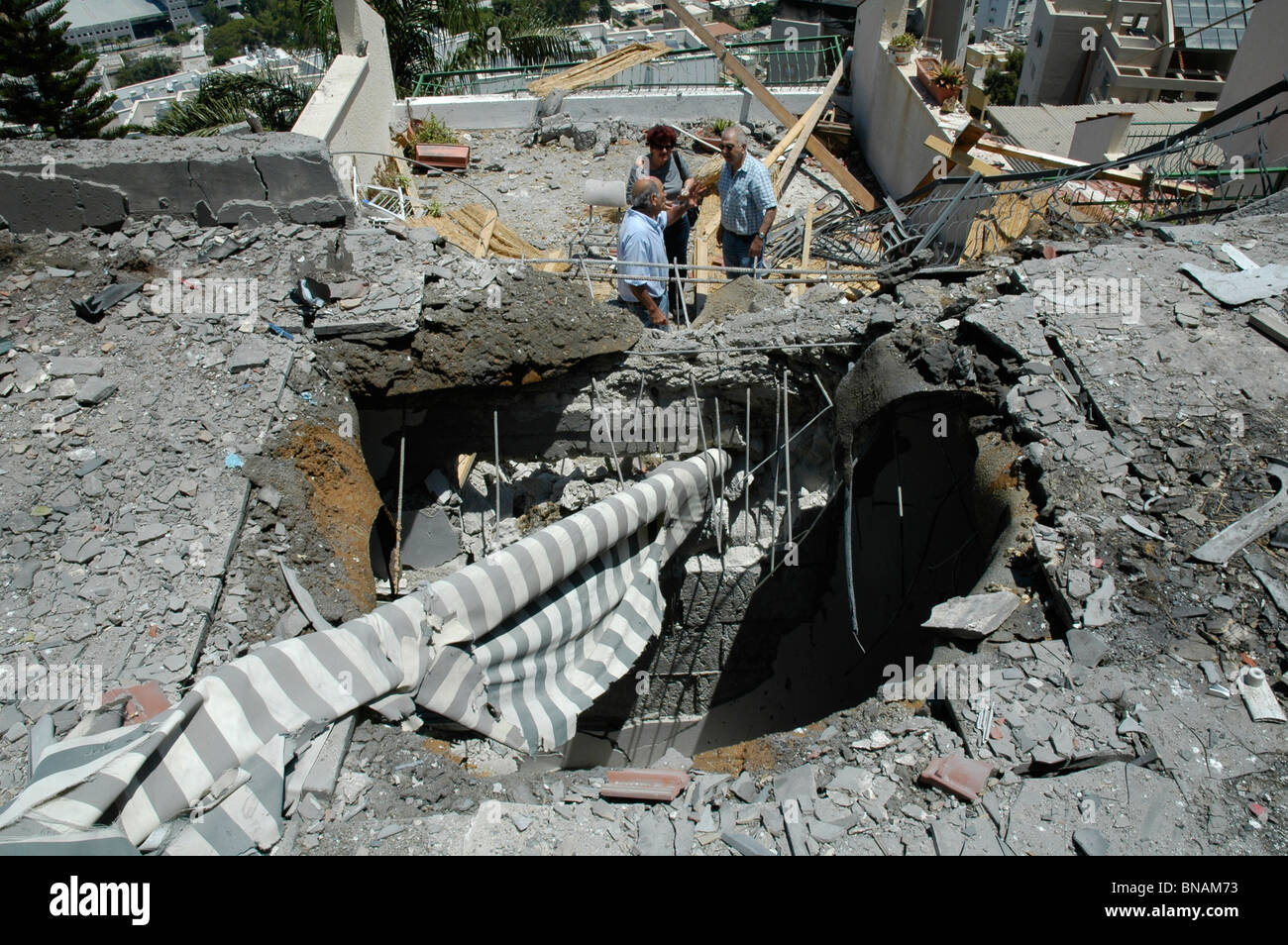 Israeli civilians stand amid the rubble of a destroyed residential ...