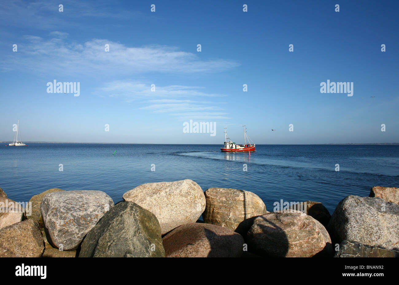 A fishing boat is leaving the harbor of Vedbæk in Denmark. Amator ...