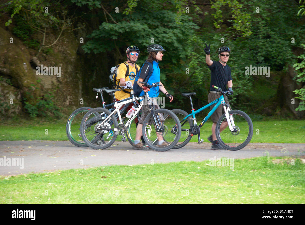 mountain bikers walking their bikes through the park Stock Photo - Alamy