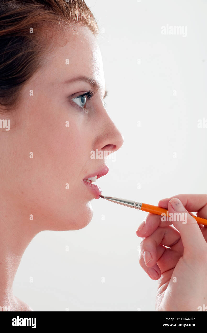 profile of a redhead woman painting her lips Stock Photo - Alamy