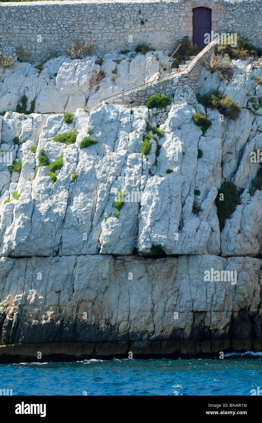 A purple door in a stone wall on top of a cliff above the sea. Ile D'If ...