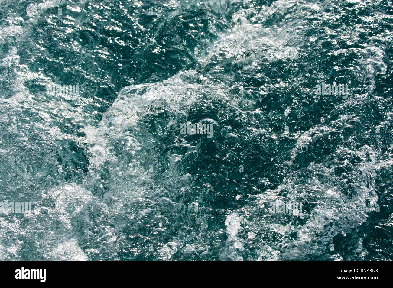 Frothy water thrown up in a boat's wake Stock Photo - Alamy